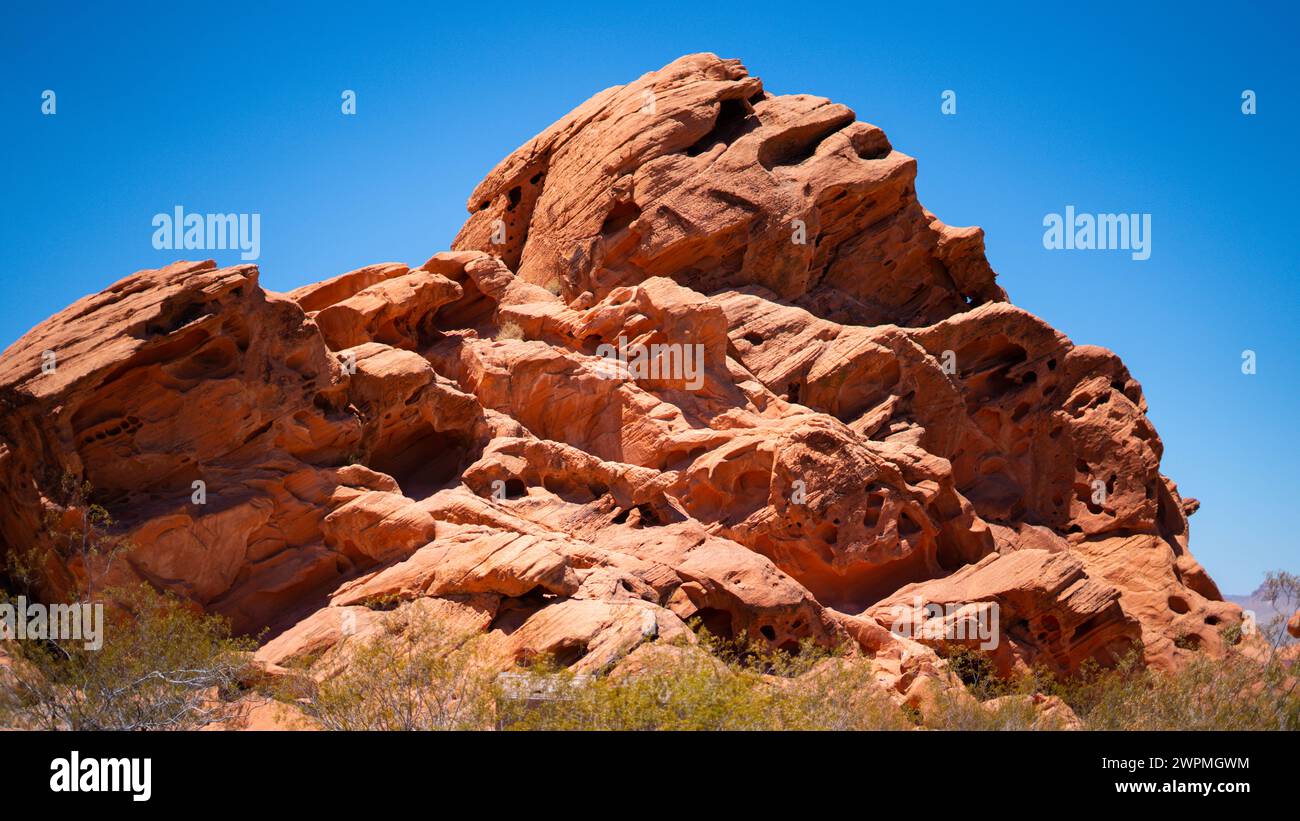 Red desert rocks under bright sun against clear blue sky Stock Photo ...