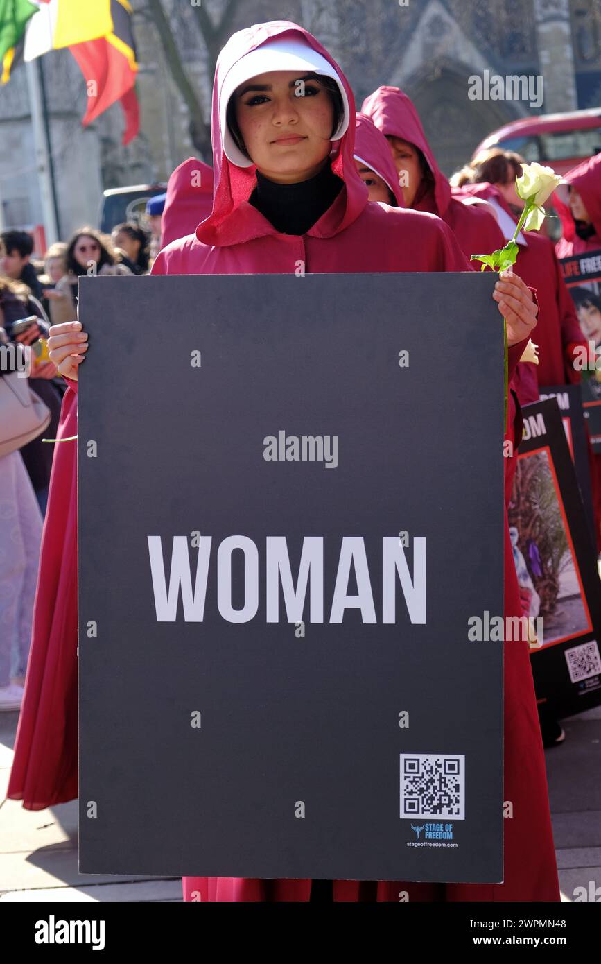 London, UK, 8th March, 2024. British-Iranians dressed in handmaids tale costumes march through ...
