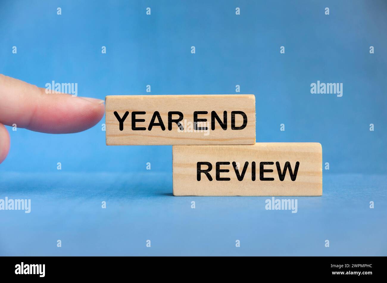 Finger pointing Year End Review text on wooden block with blue background. Mid Term budgeting ...