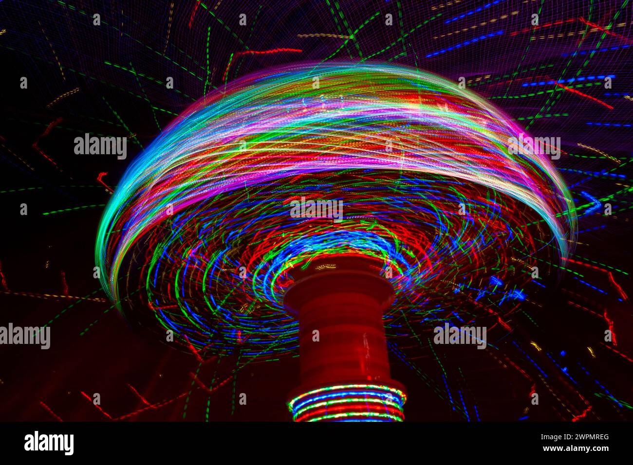 Carnival amusement park ride with swings. Spinning fair ride at night ...