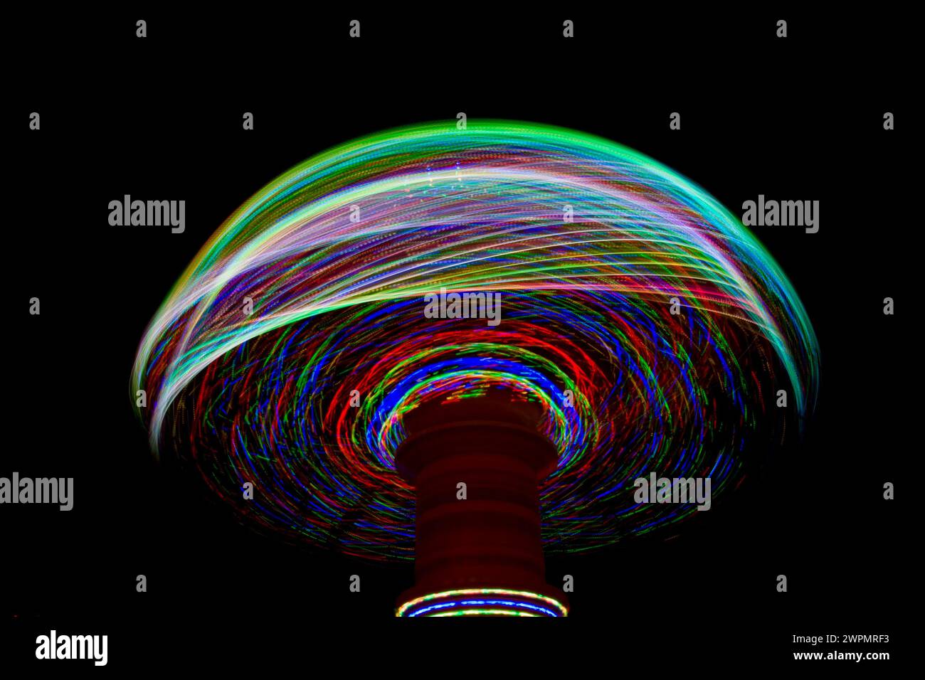 Carnival amusement park ride with swings. Spinning fair ride at night ...