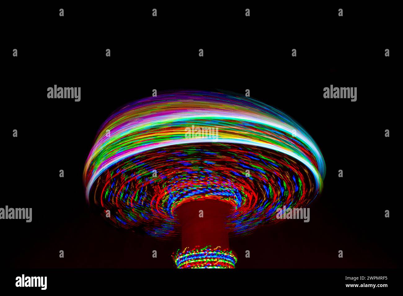 Carnival amusement park ride with swings. Spinning fair ride at night ...