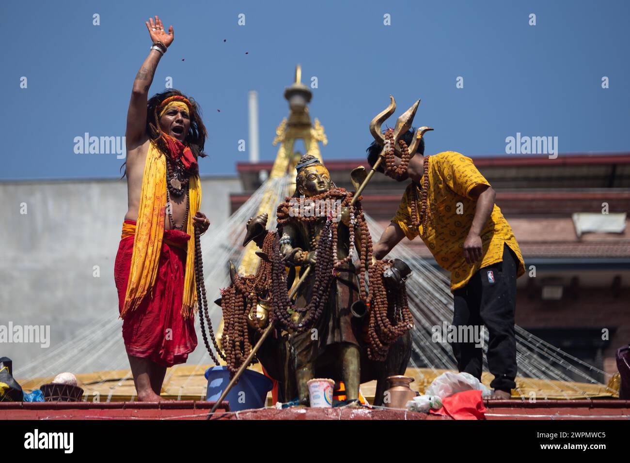 A priest adorns the idol of Lord Shiva with milk, marking the sacred ...