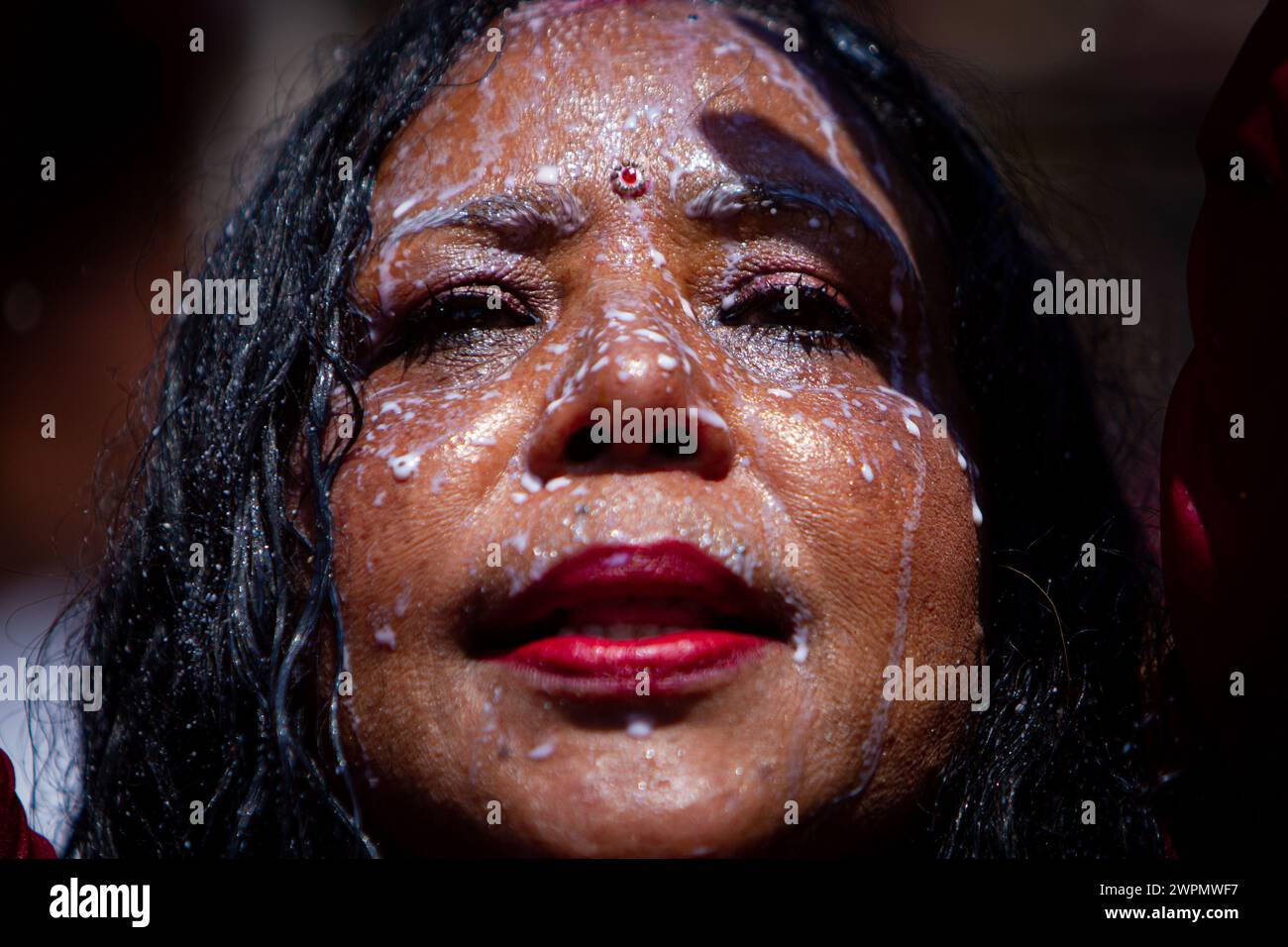 A priest adorns the idol of Lord Shiva with milk, marking the sacred ...
