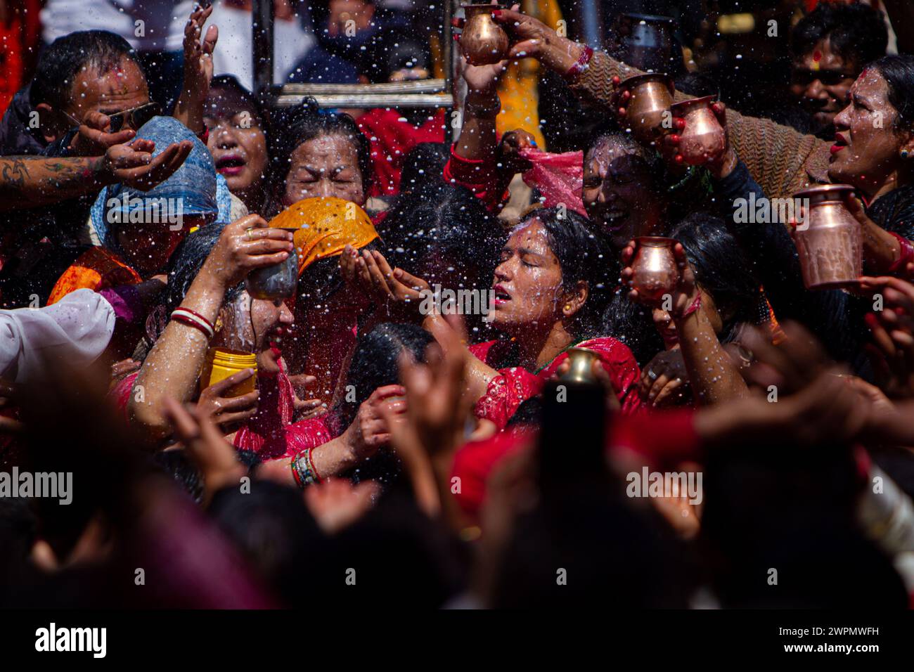 A priest adorns the idol of Lord Shiva with milk, marking the sacred ...