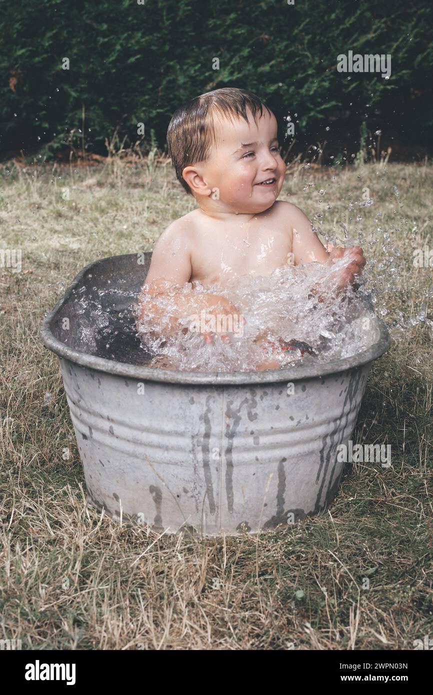 Little boy chilling in small retro sheet metal bathtub Stock Photo - Alamy