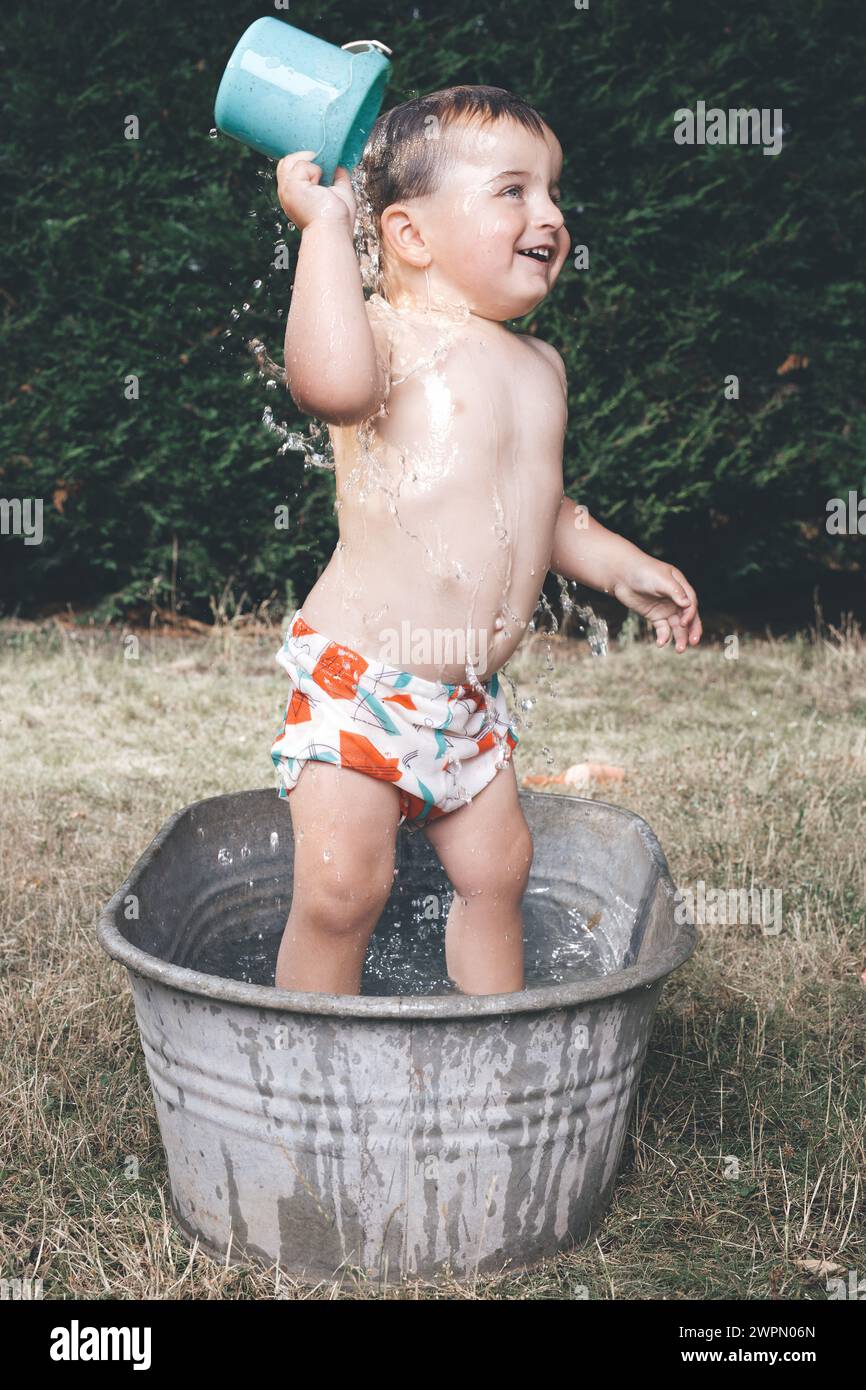 Little boy chilling in small retro sheet metal bathtub Stock Photo - Alamy
