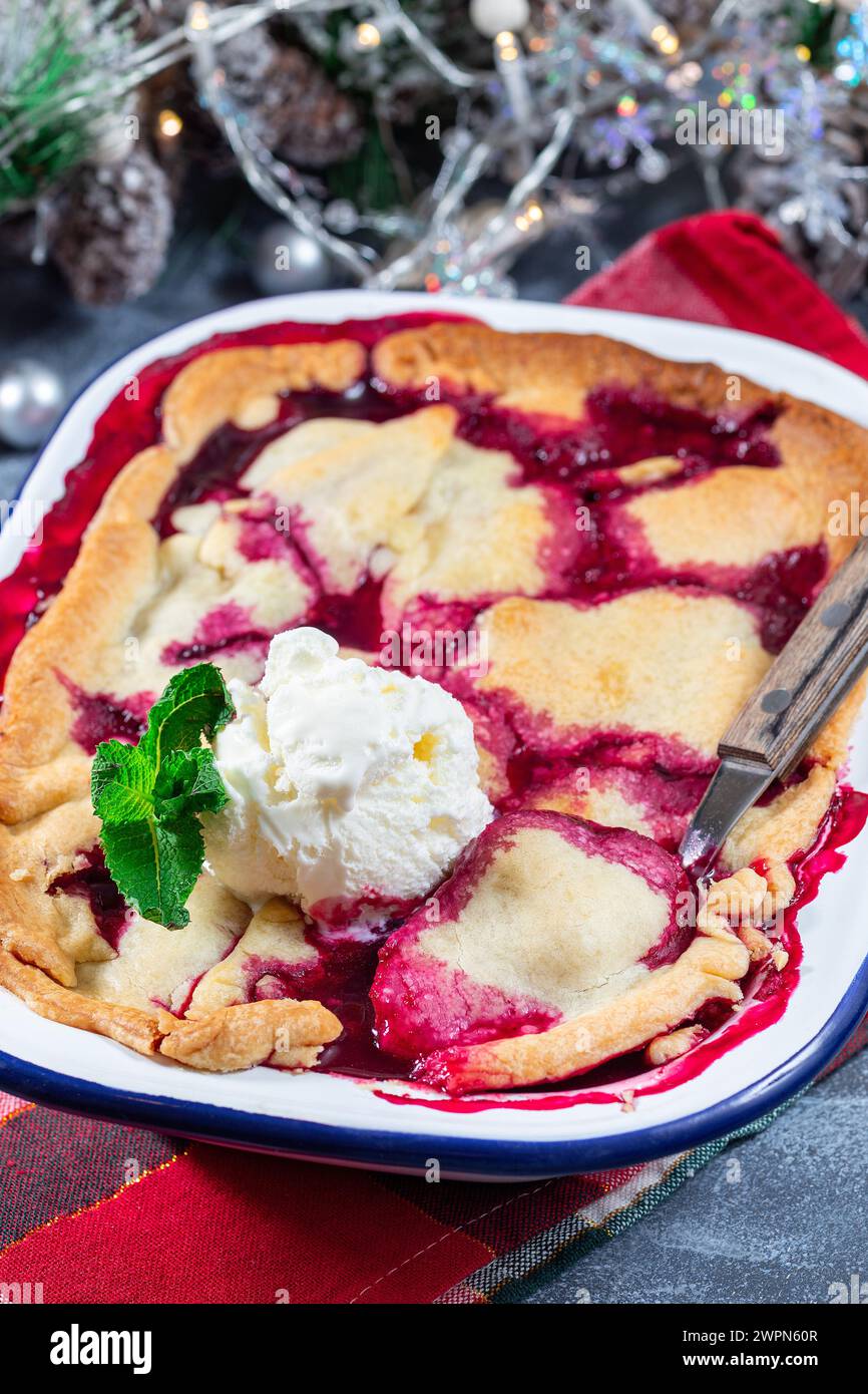 Delicious berry cobbler in enamel baking dish, garnished with ice cream ...
