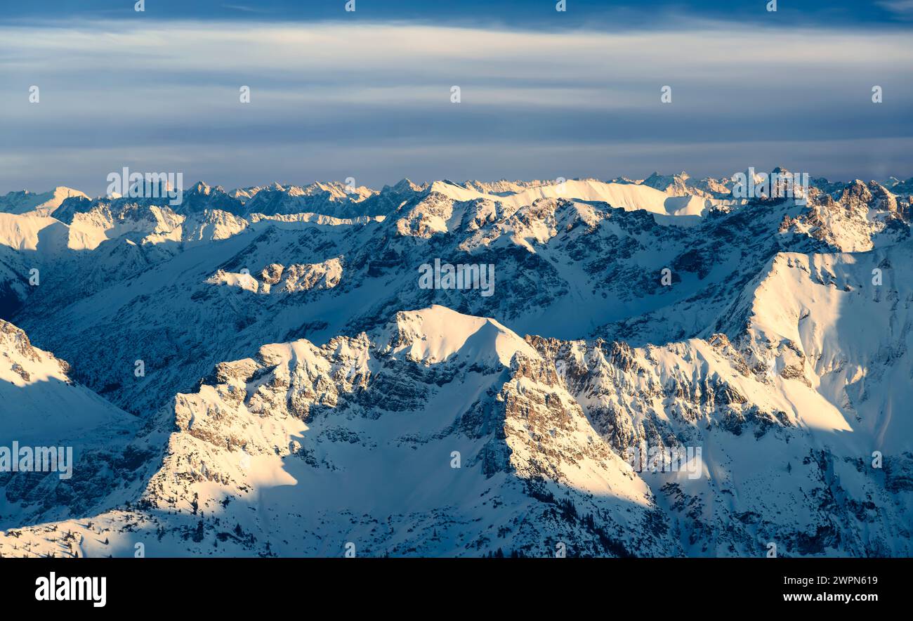 Snow-covered mountain peaks in the light of the low winter sun. View of ...