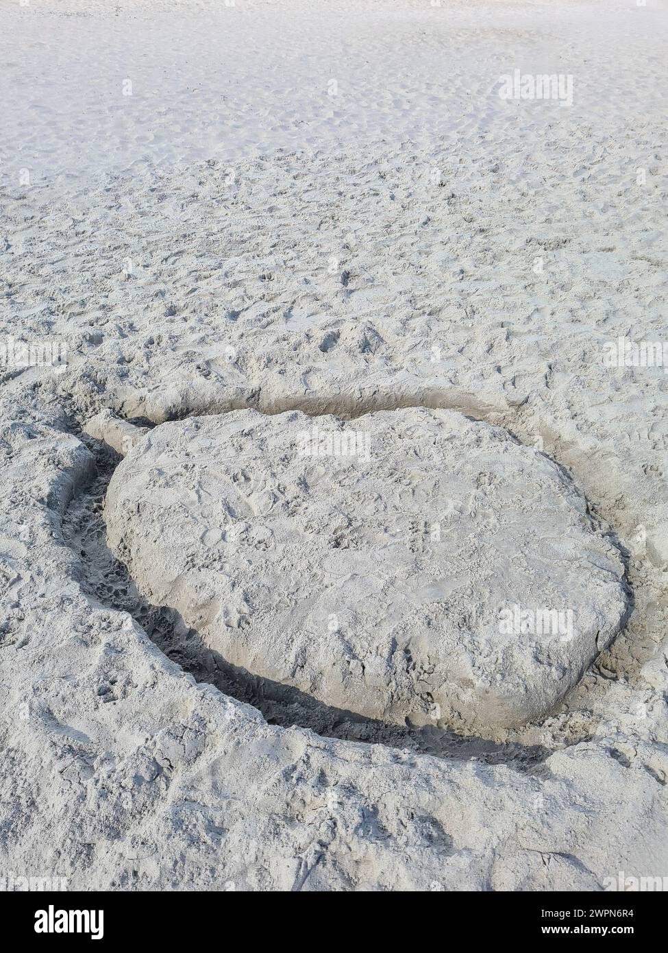 Symbolic shape like a pear built in the sand on the bright sandy beach ...