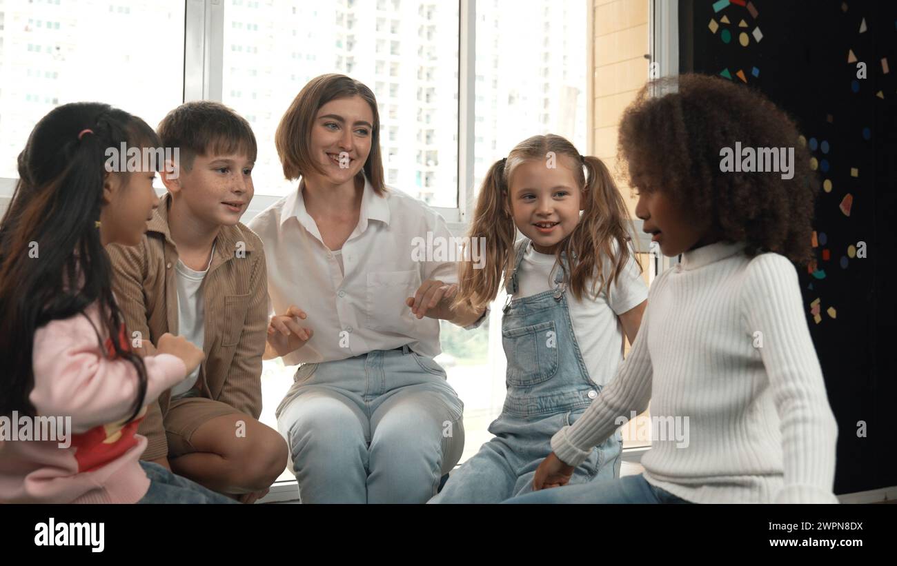 Smart caucasian teacher teaching while sitting on floor together ...