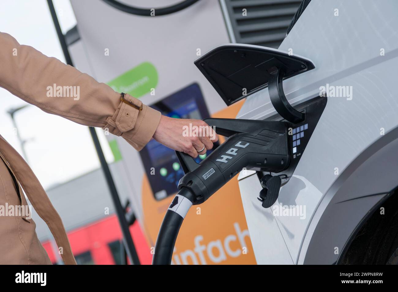 Woman charging an electric car at the fast charging park hi-res stock ...