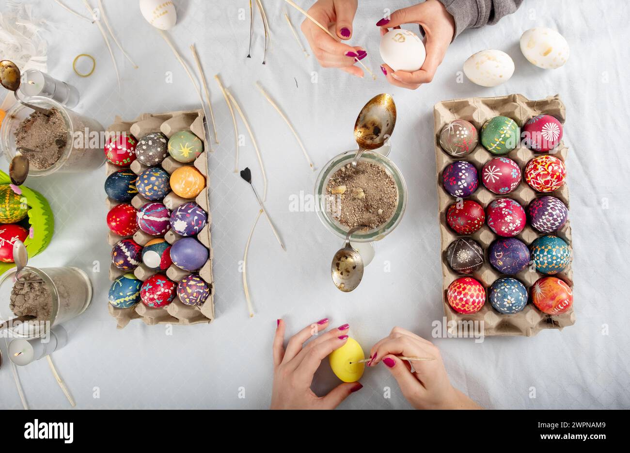 human hands of two sorbian women are painting with melting wax with a ...