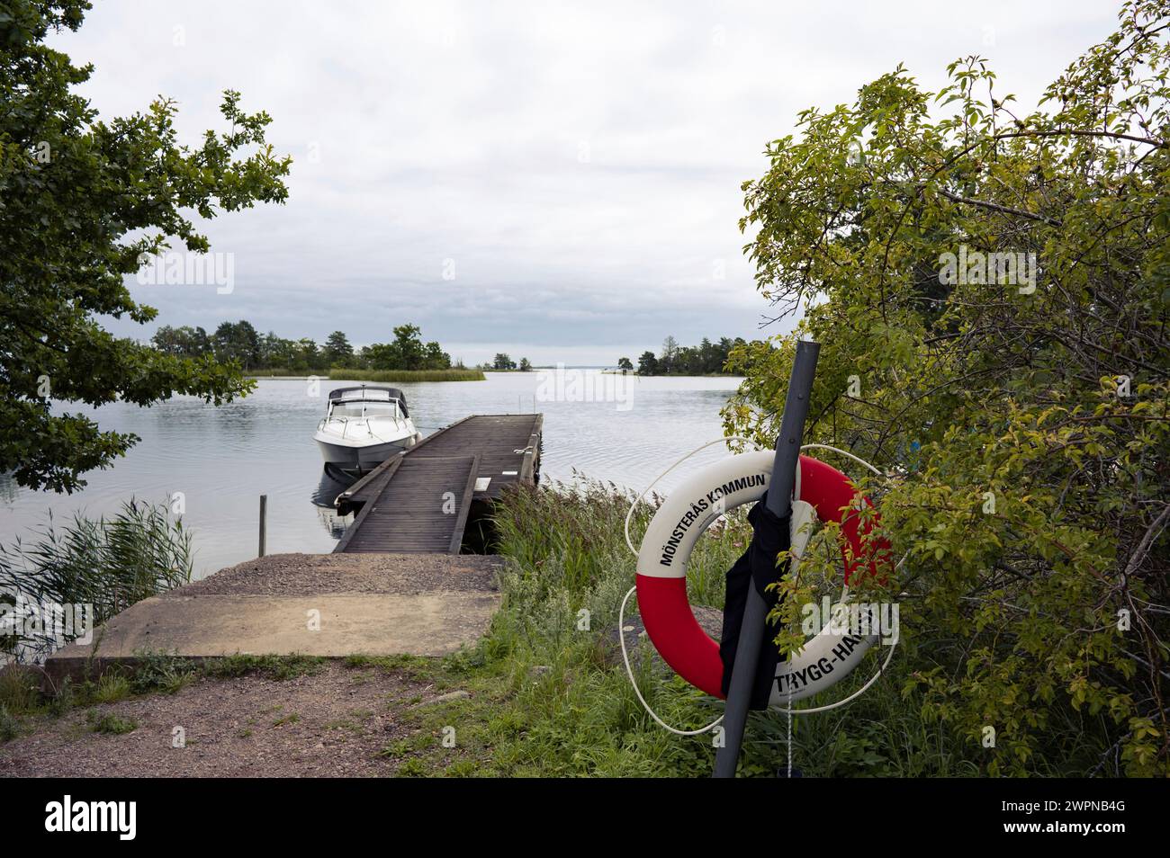 Wooden jetty with motorboat and lifebuoy on an archipelago coast Stock ...