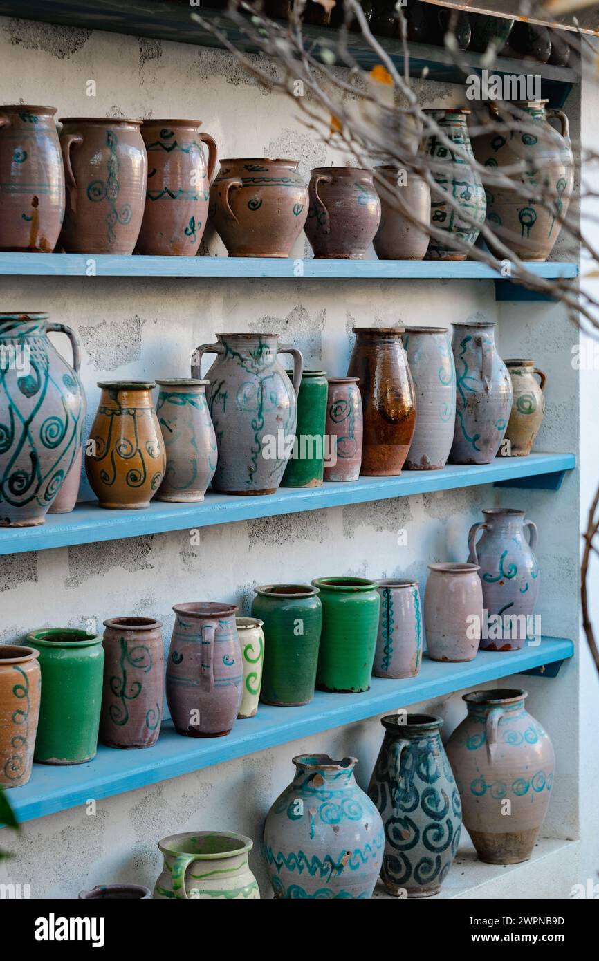 Artfully crafted pottery pieces adorn blue shelves, showcasing a rich ...