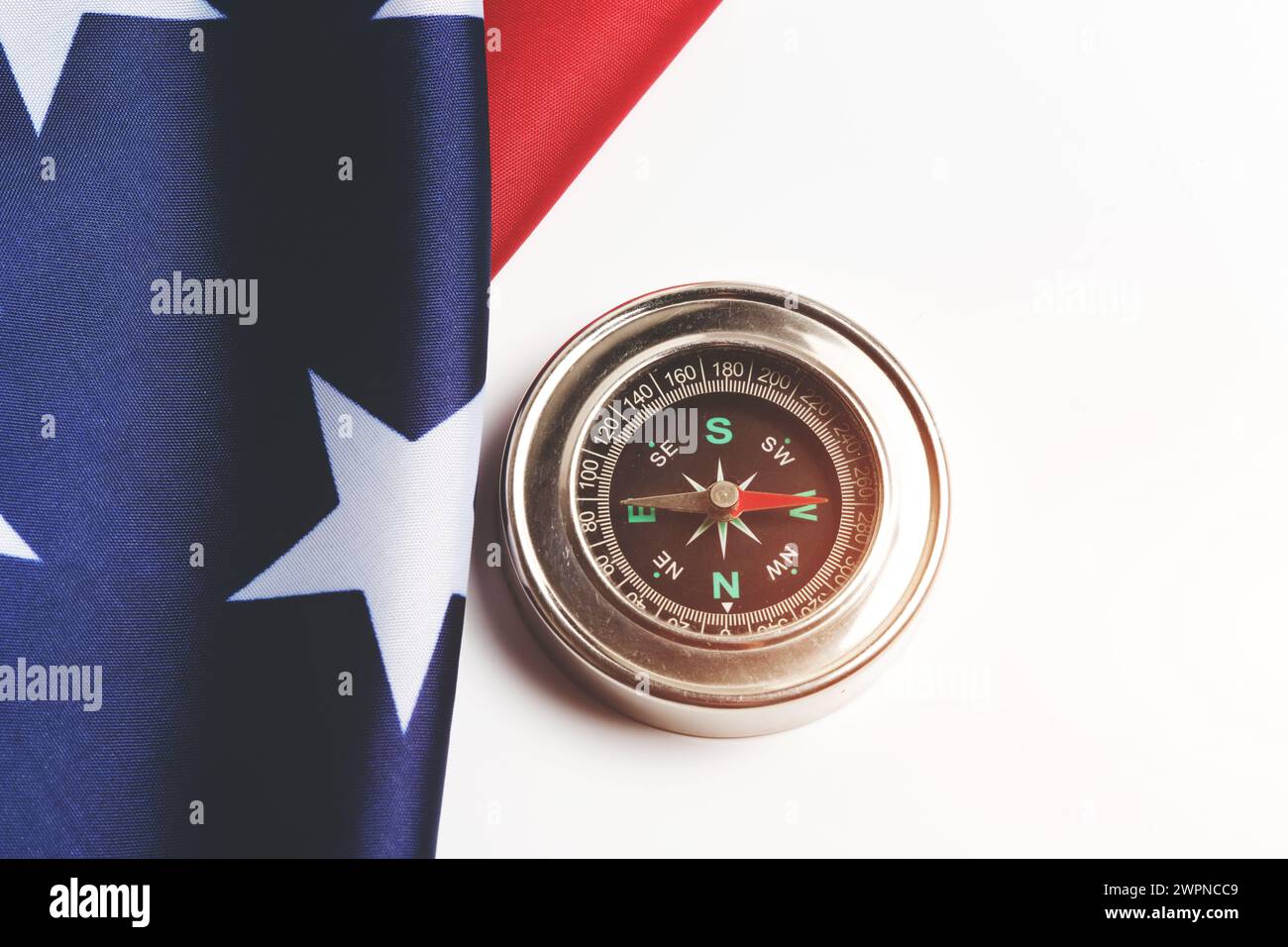 Compass pointing west and star spangled flag United States America ...