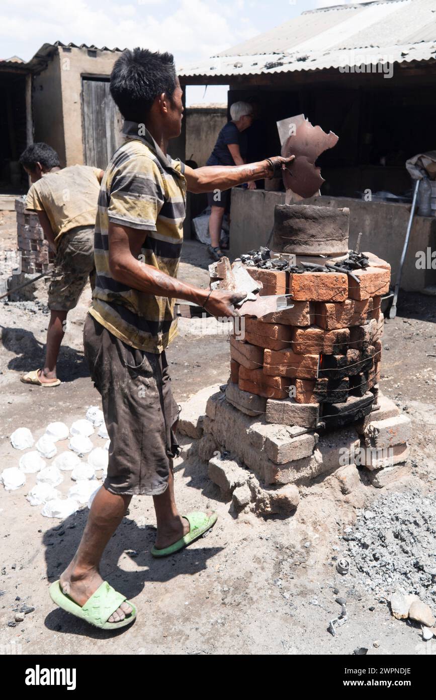 Putting scrap aluminium in a melting furnace in aluminium recycling ...