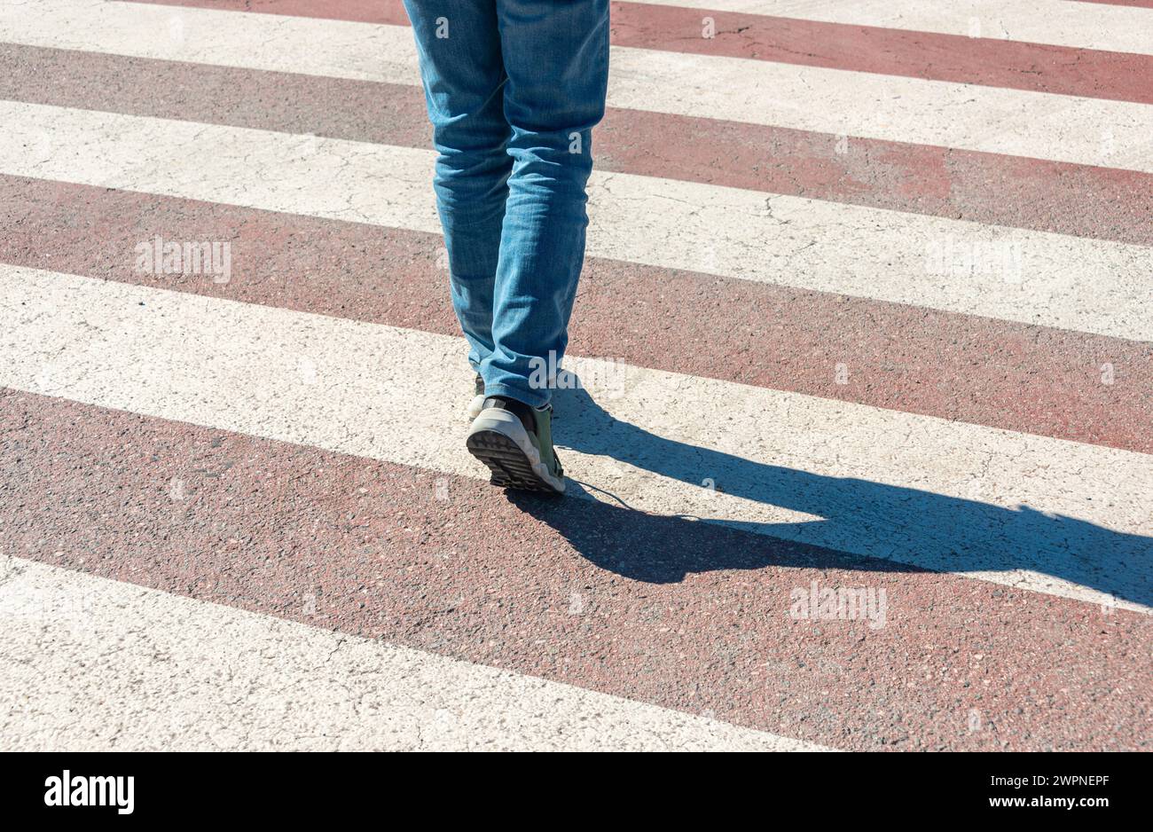 woman in jeans walking across a pedestrian crossing, close up Stock ...