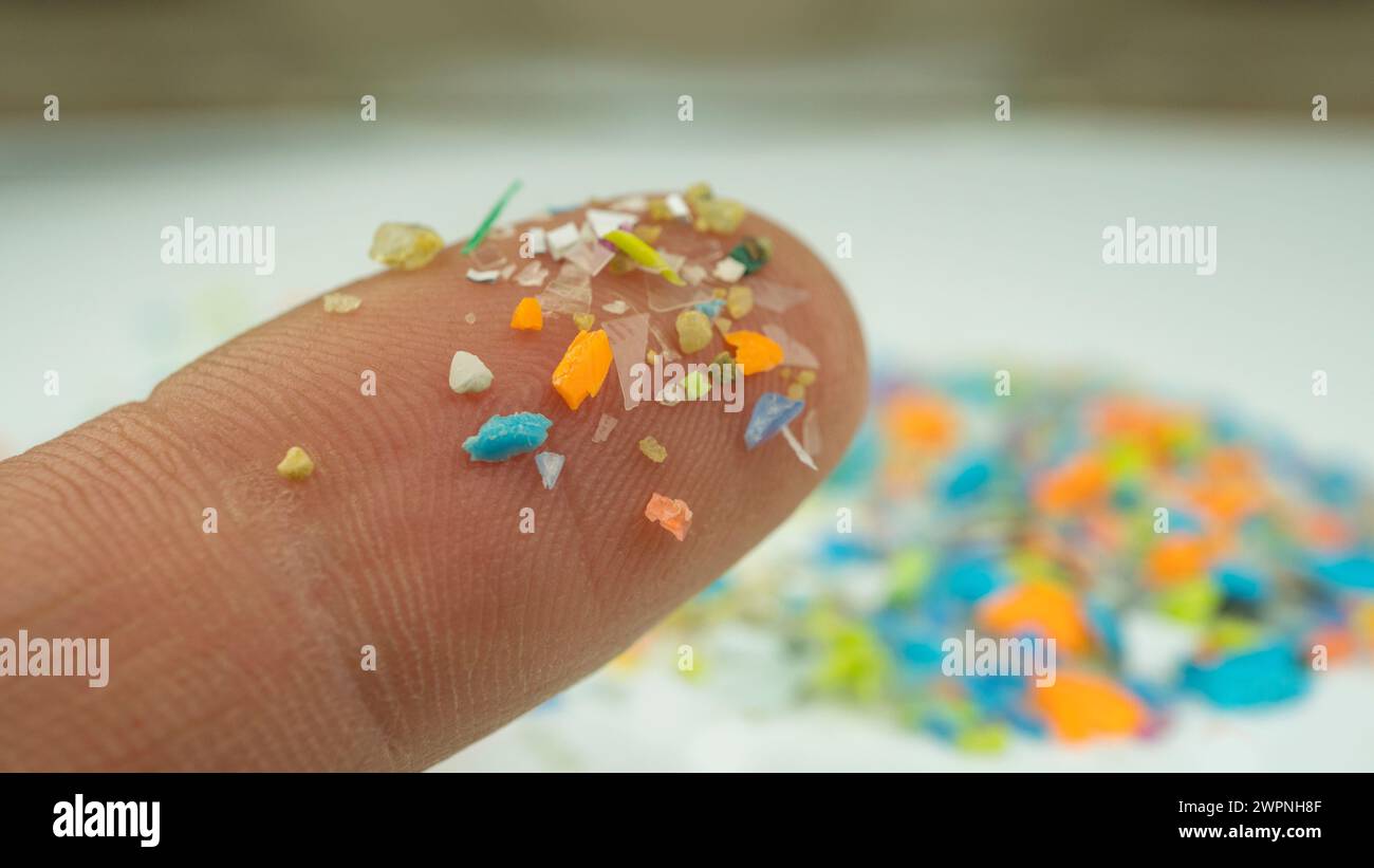 Macro shot of microplastics on human finger. Concept of plastic ...
