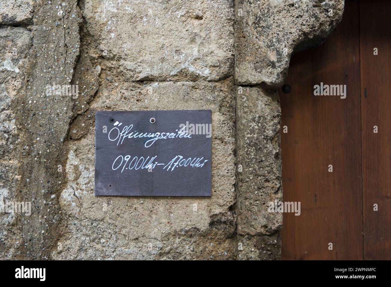 Sign, opening hours, house wall Stock Photo - Alamy