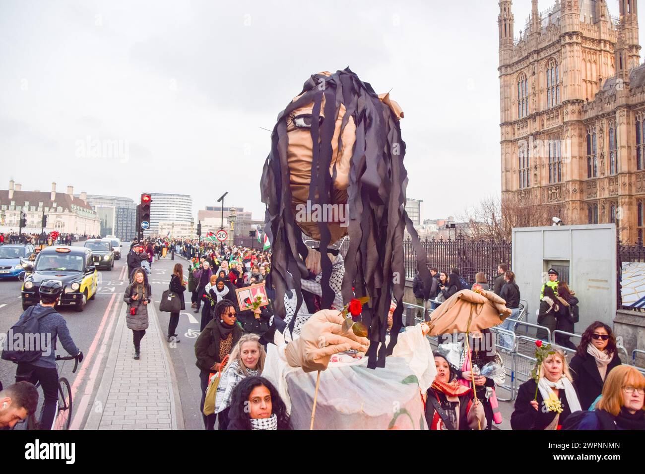 London, UK. 8th March 2024. Pro-Palestine protesters carry a giant ...