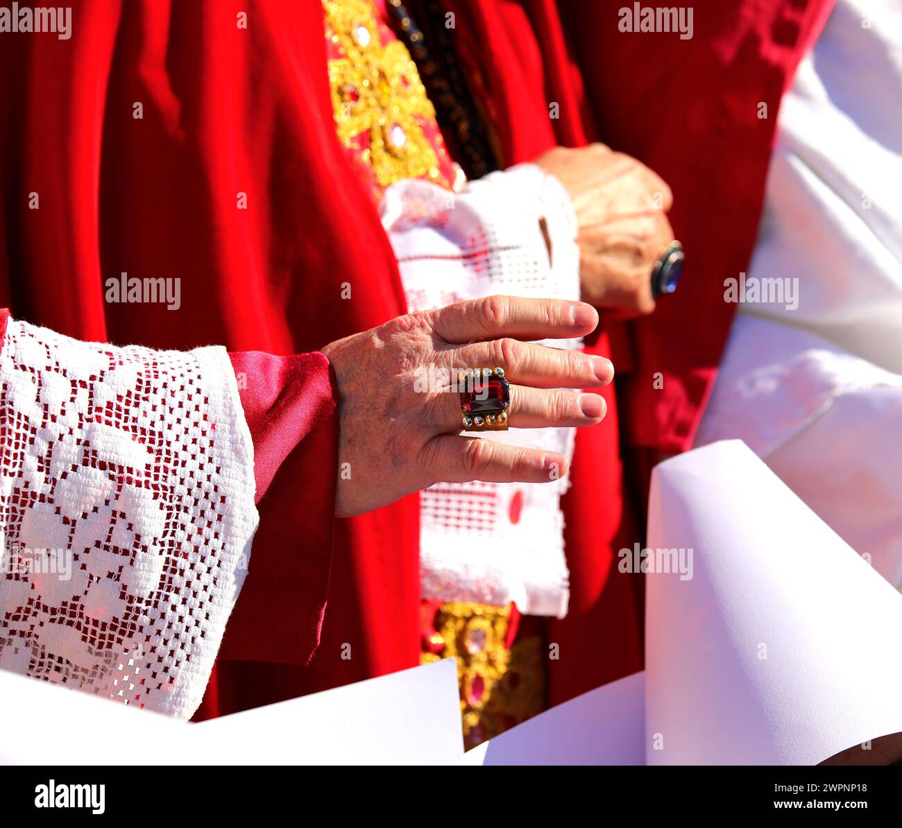 Bishop in red religious attire blesses the faithful with hand and large ...