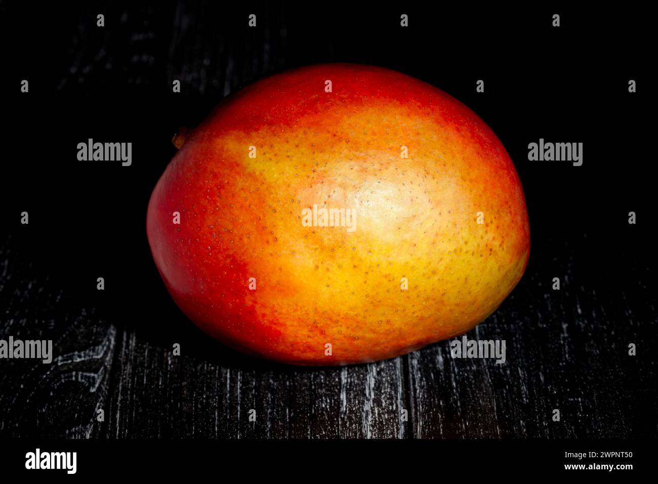 mango on black wood background Stock Photo - Alamy
