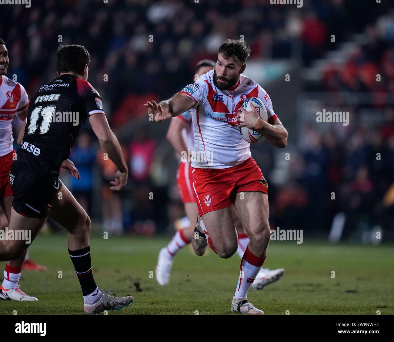 Alex Walmsley of St. Helens runs at the Salford Red Devils defence ...
