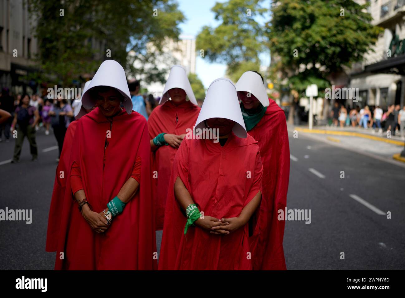 Women in red cloaks and white bonnets, dressed like the characters from ...
