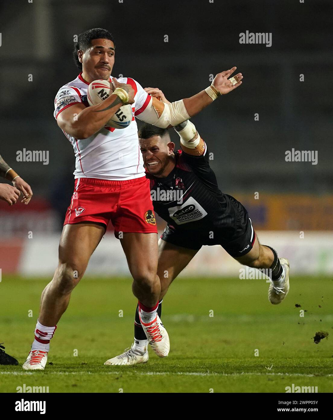 St Helens' Sione Mata'utia is tackled by Salford Red Devils' Cade Cust ...