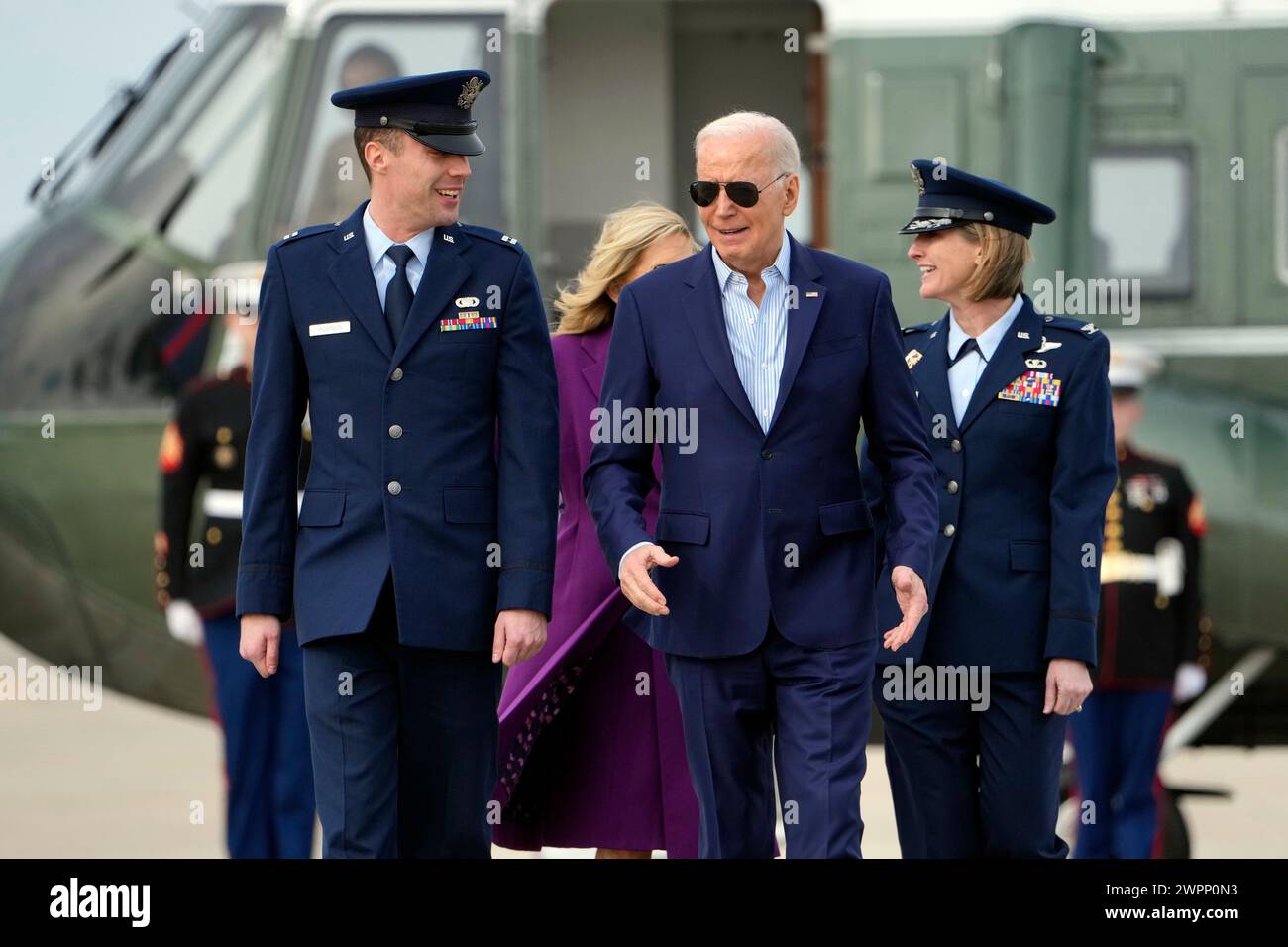 President Joe Biden walks with Capt. Eric Anderson, deputy director of ...