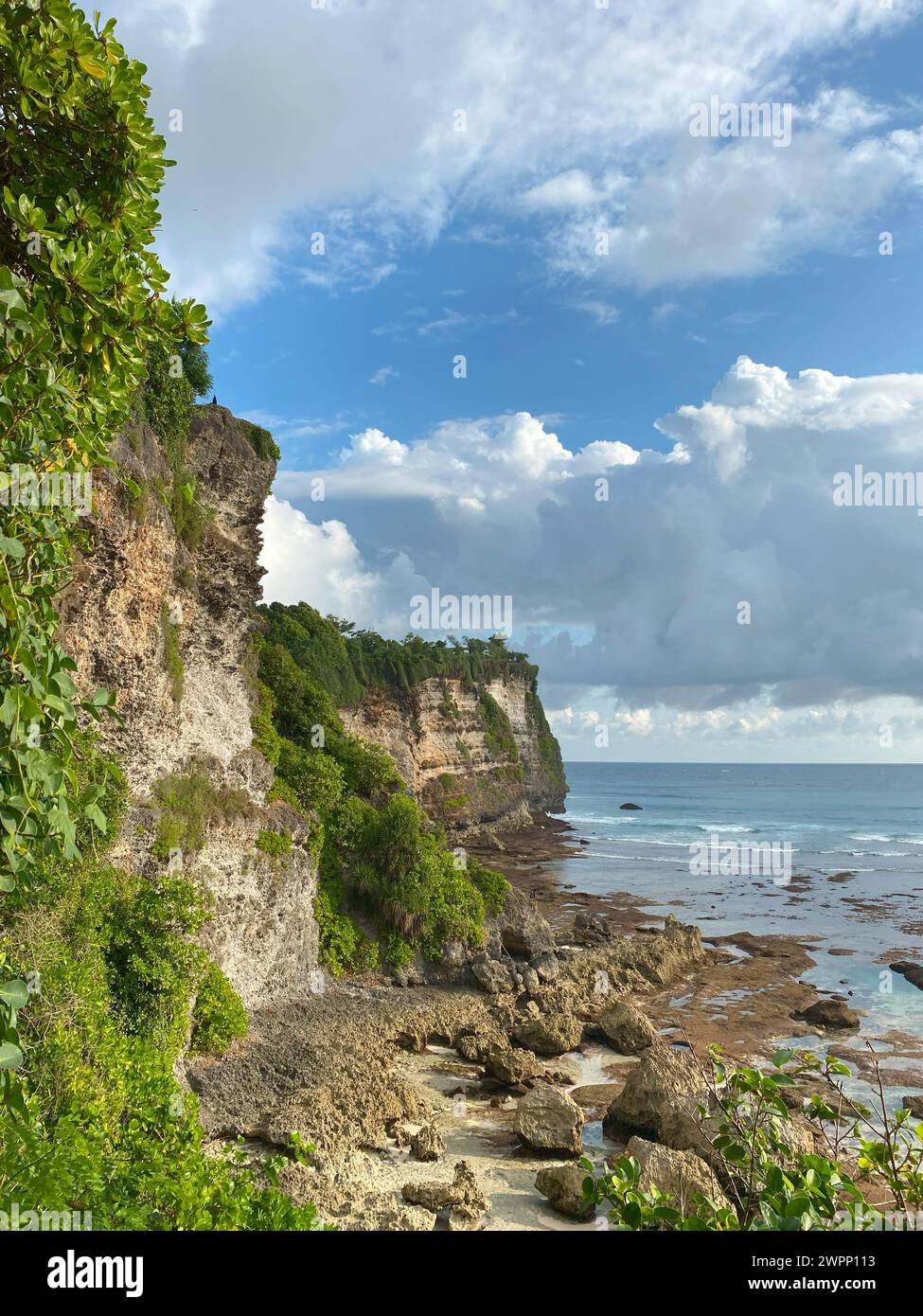 The sheer cliffs of the southern coast of Bali are washed by a clear azure ocean. Bukit ...
