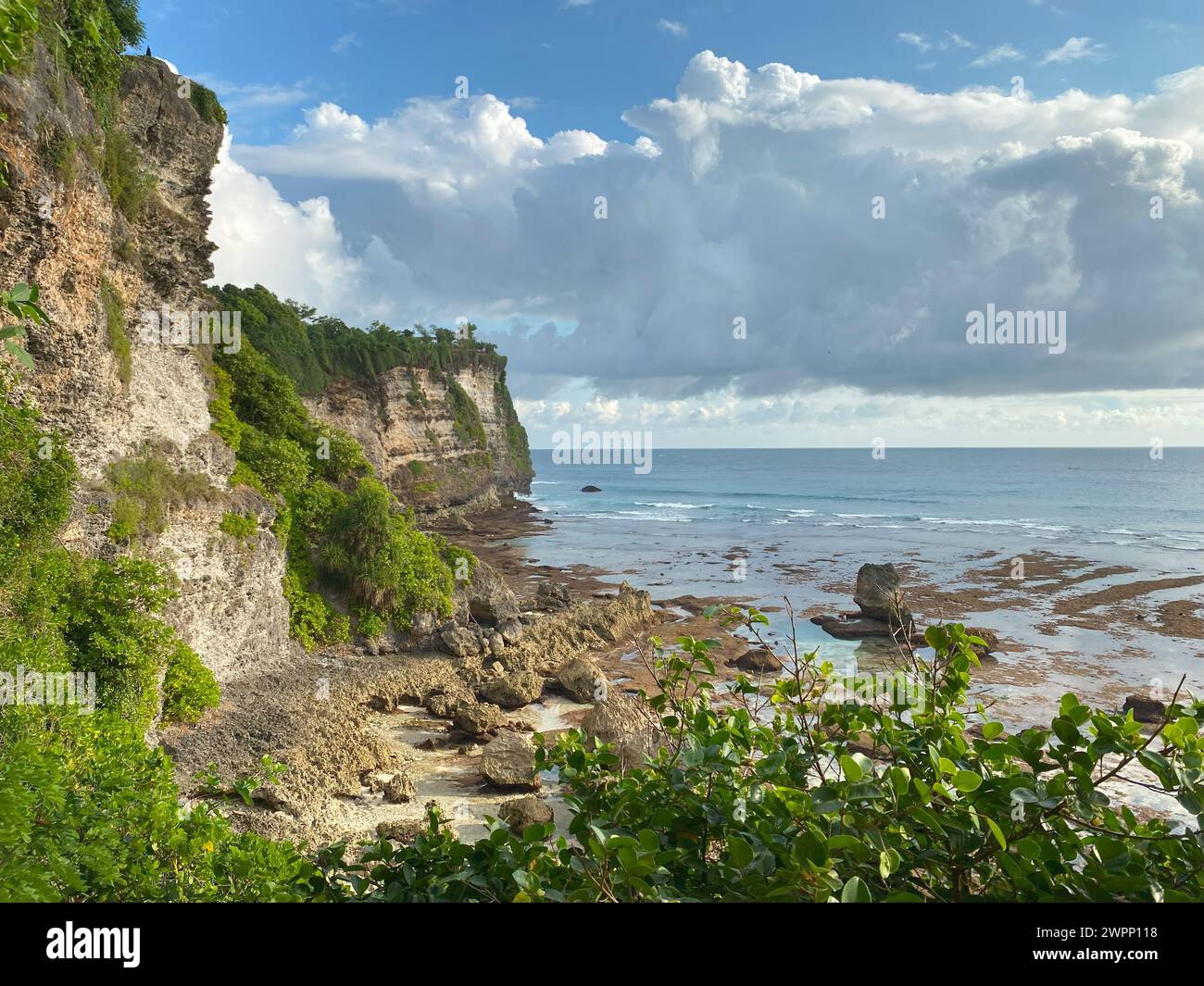 The sheer cliffs of the southern coast of Bali are washed by a clear ...