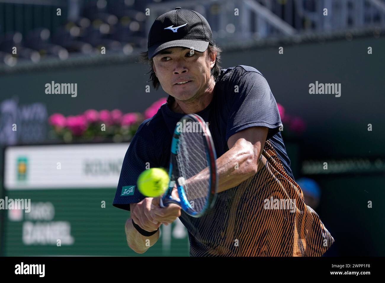 Taro Daniel, of Japan, returns a shot against against Alex de Minaur ...