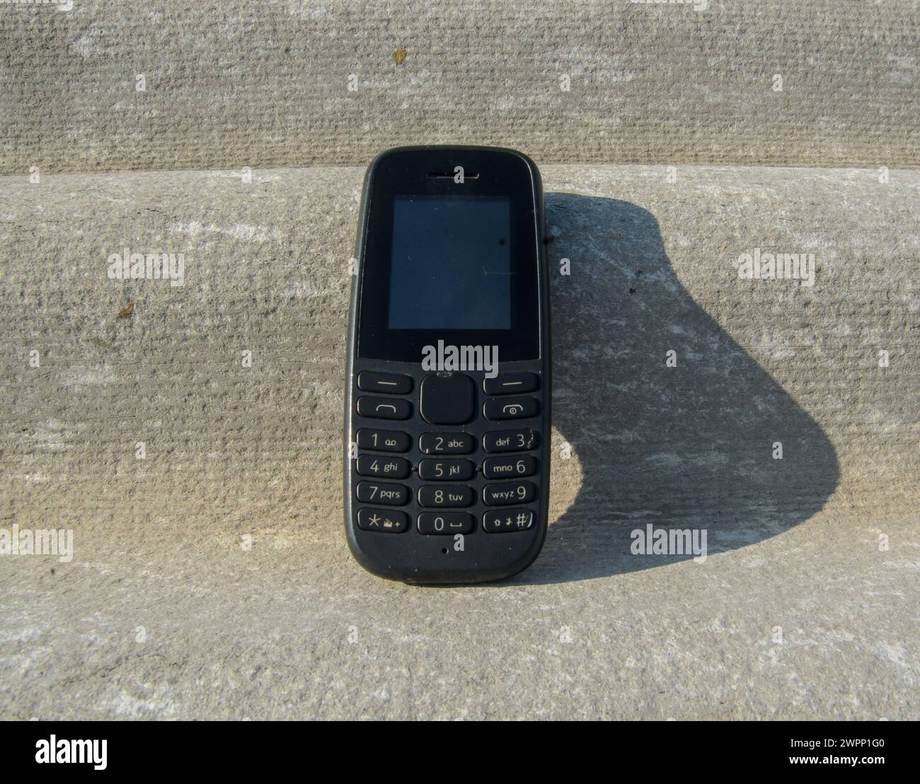 The old keypad phone on the ground Stock Photo - Alamy