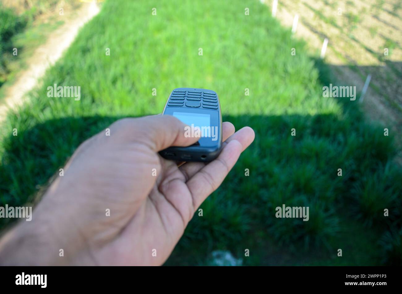 The old keypad phone holding up in hand Stock Photo - Alamy