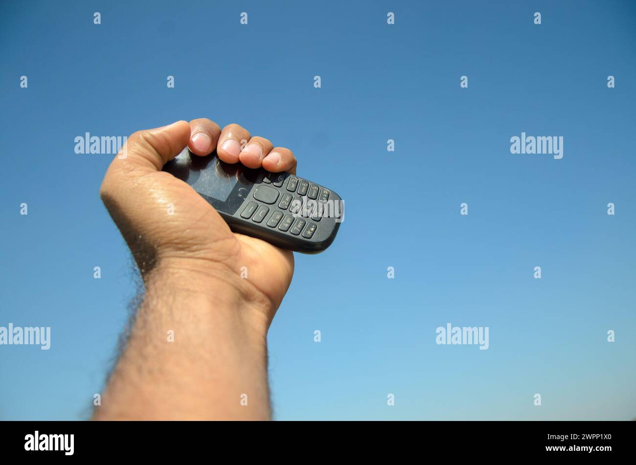 The old keypad phone holding up in hand Stock Photo - Alamy
