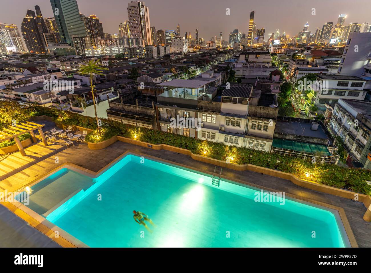 Illuminated swimming pool in front of the city view and skyline of ...