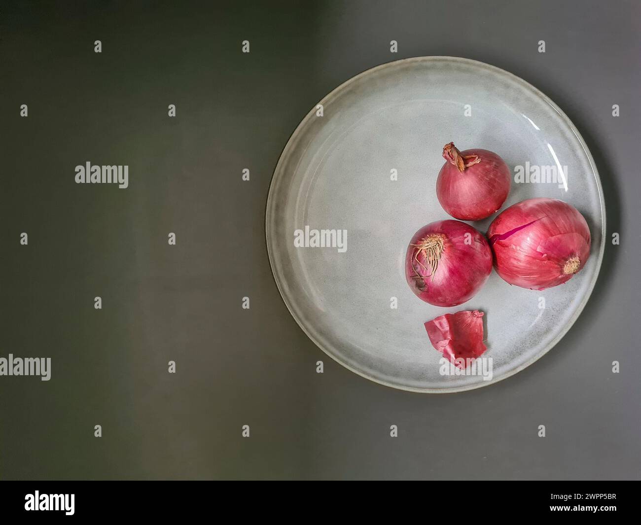 Still life with red onions and onion skin on a ceramic plate Stock ...