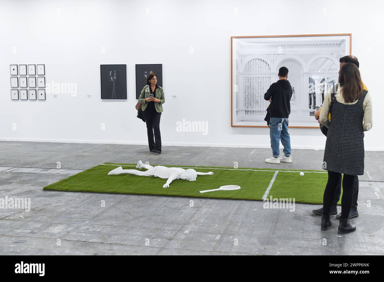 People admire different art works displayed in a gallery during the ...