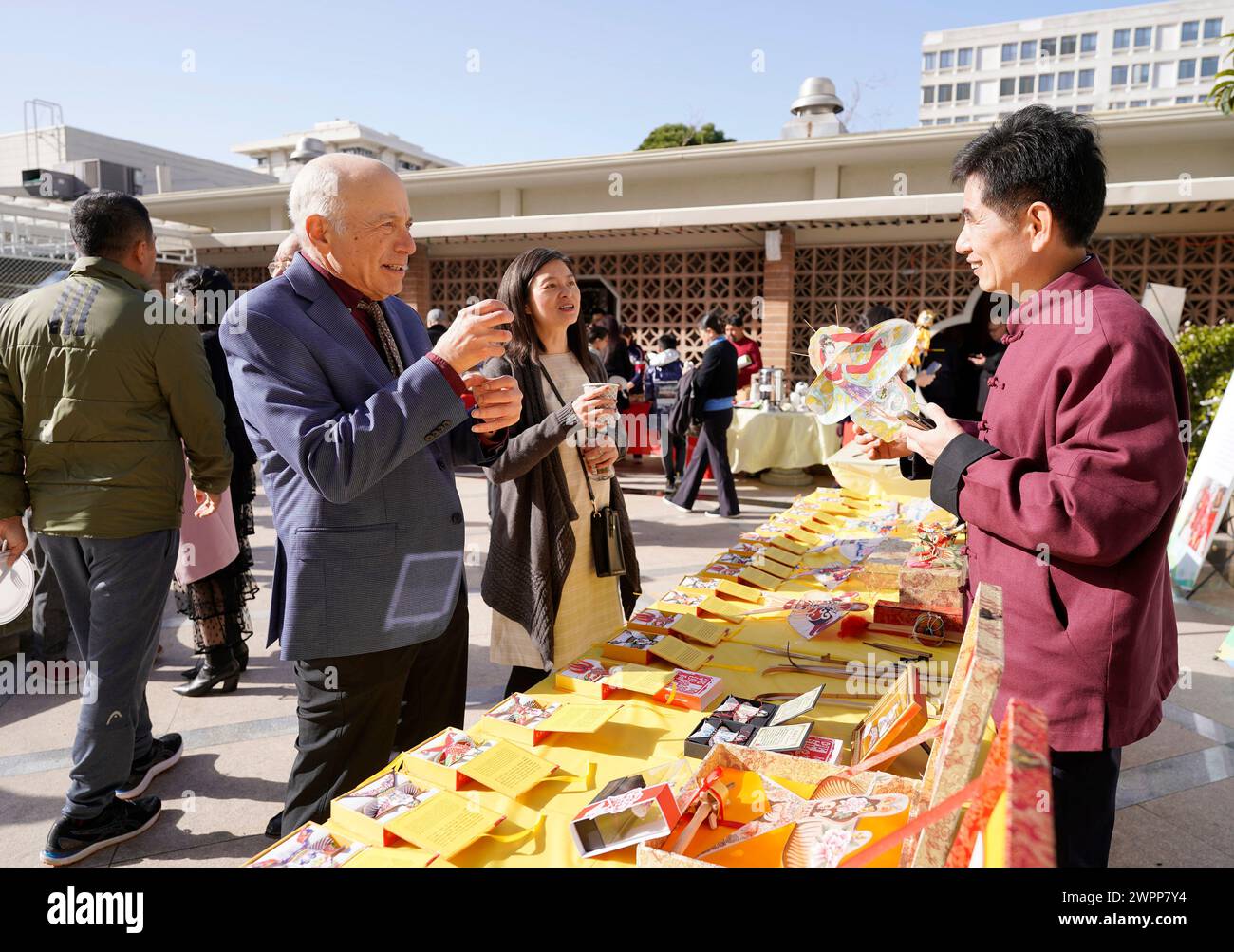 San Francisco, USA. 7th Mar, 2024. People talk at a stall displaying ...
