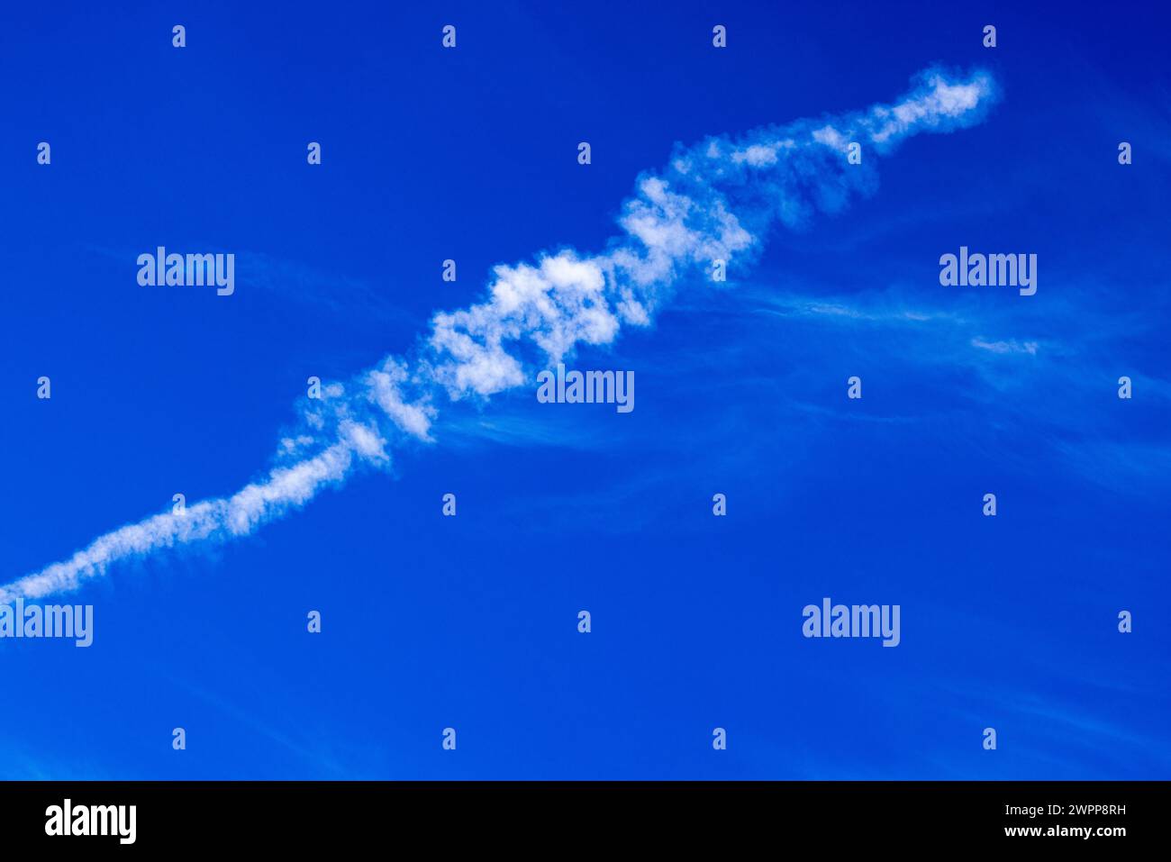 Cirrus clouds ruffled by the wind against a blue sky background ...