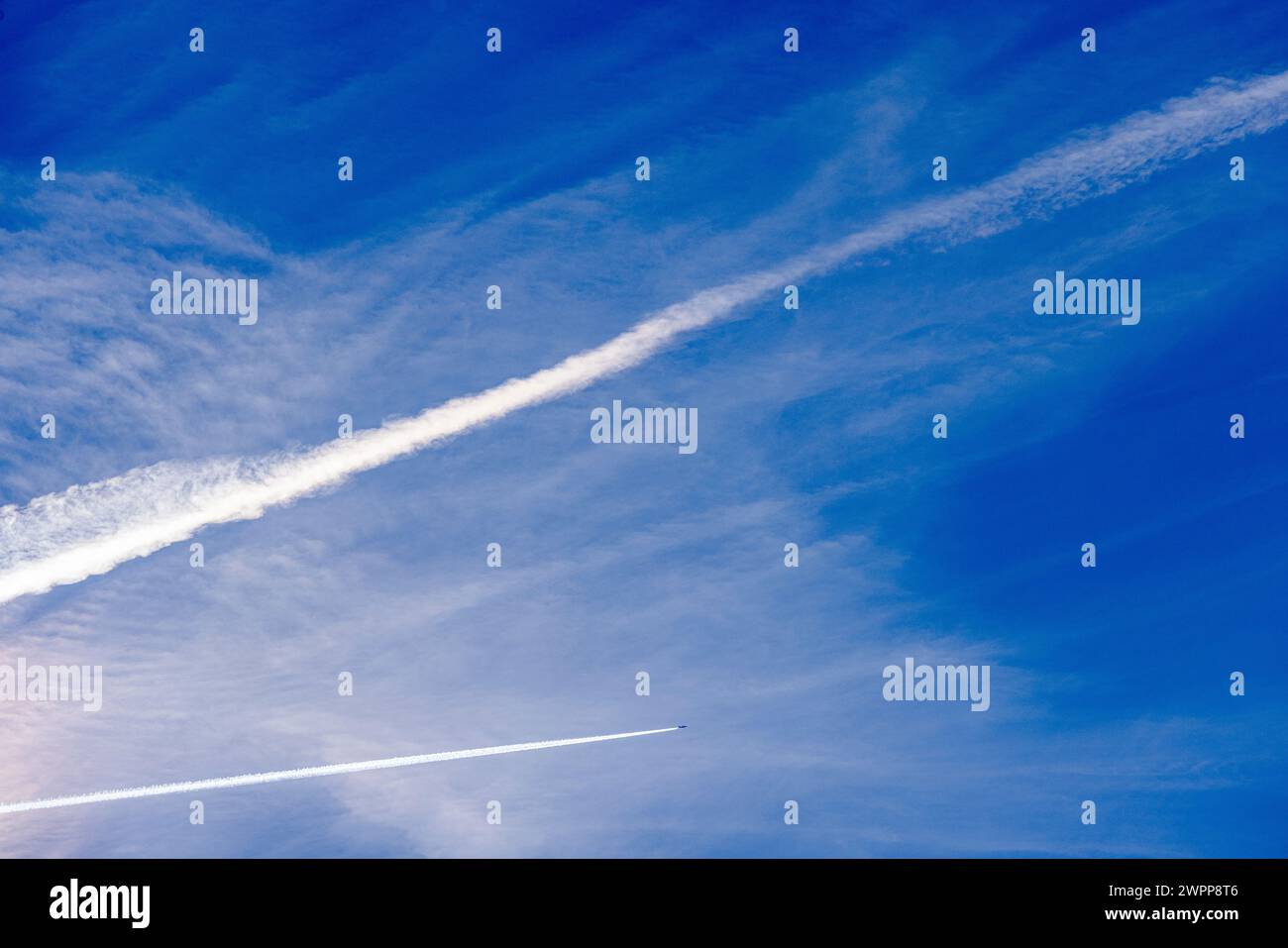 Cirrus clouds ruffled by the wind against a blue sky background ...