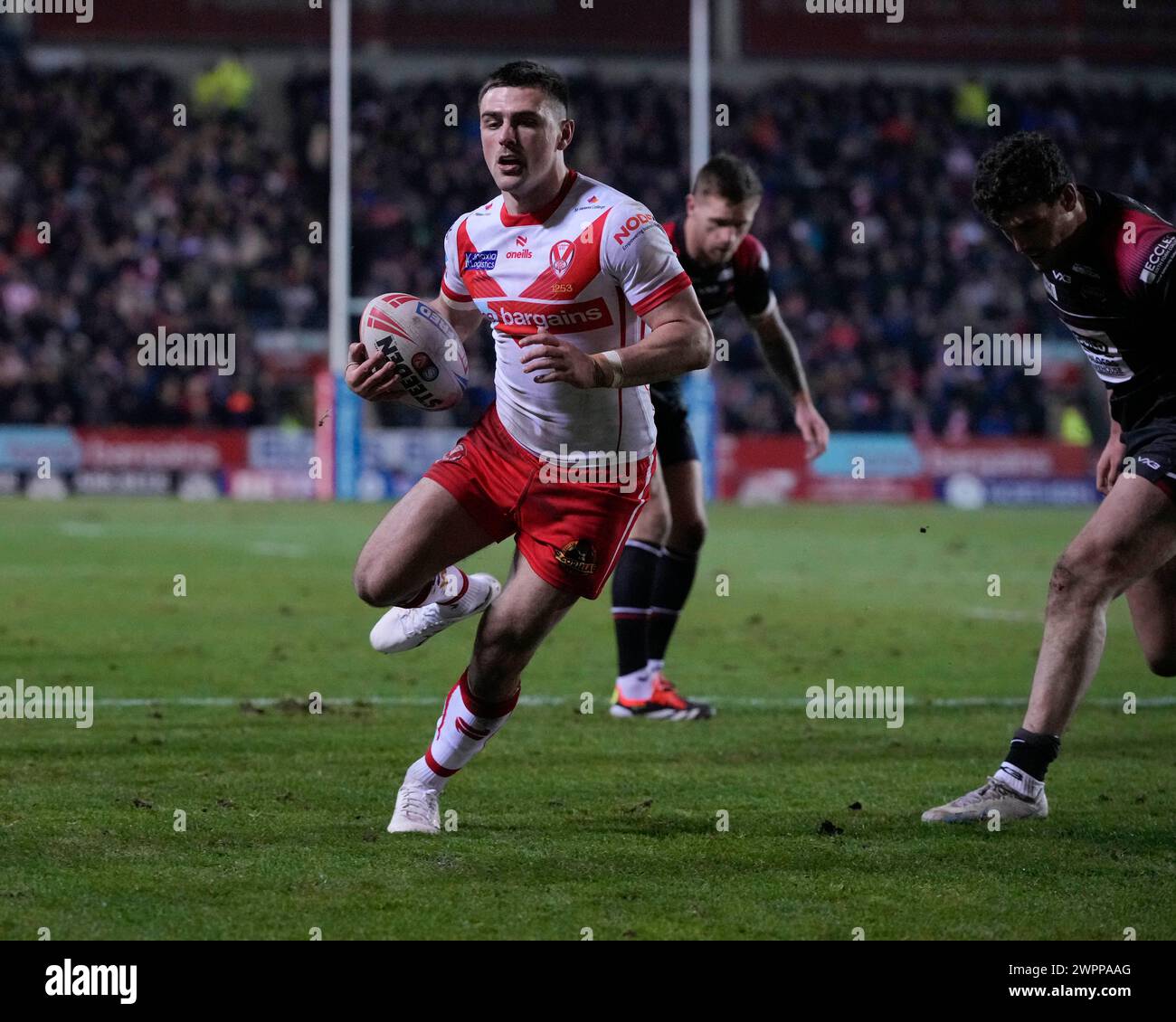 Lewis Dodd of St. Helens breaks through the Salford Red Devils defence ...