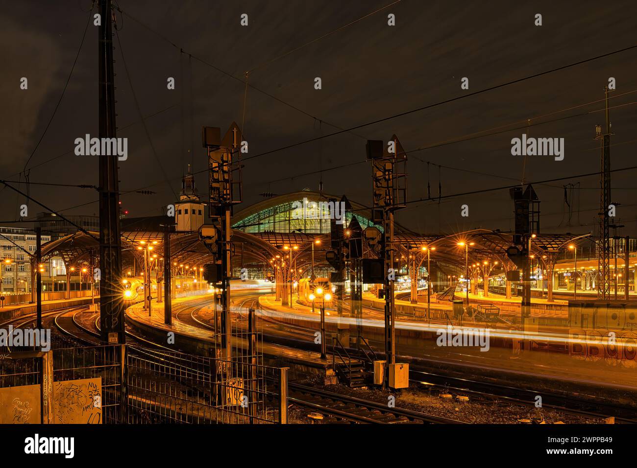 Night scene with illuminated tracks, light poles at the main station of ...