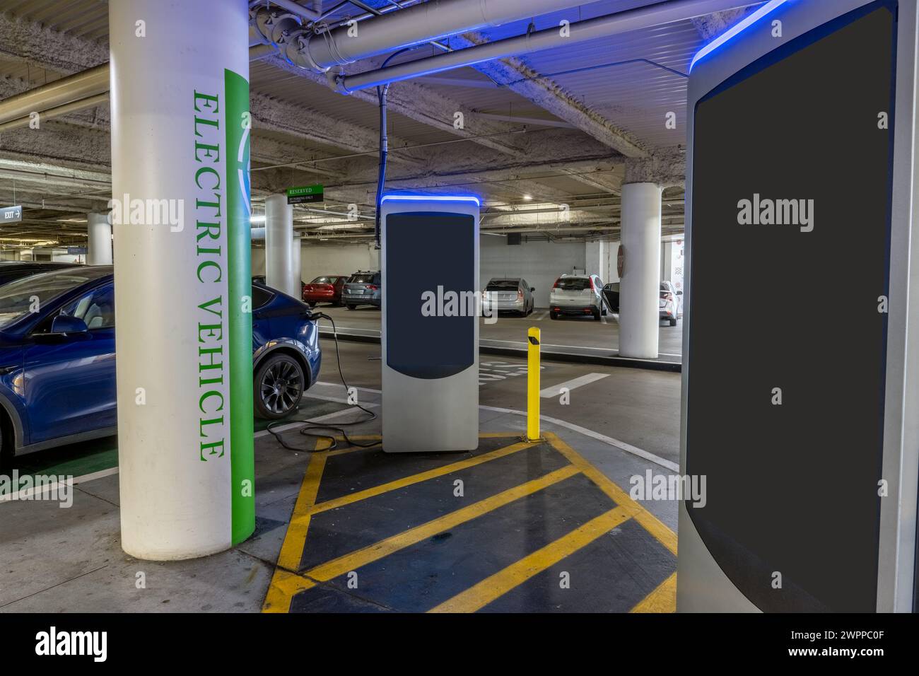 Electric vehicle charging station at parking structure has one car ...