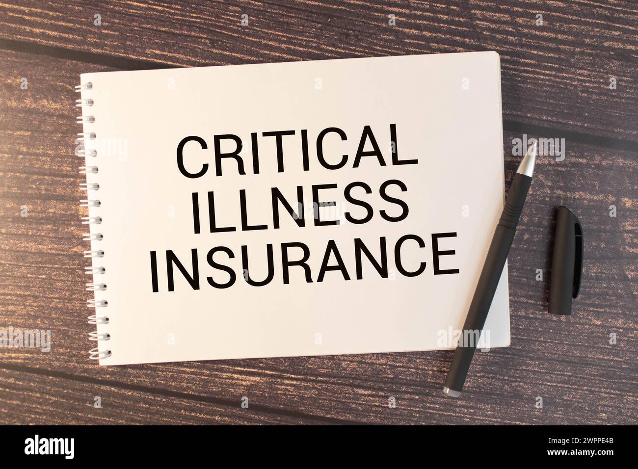 Notepad with text CRITICAL ILLNESS INSURANCE. Diagram and white ...