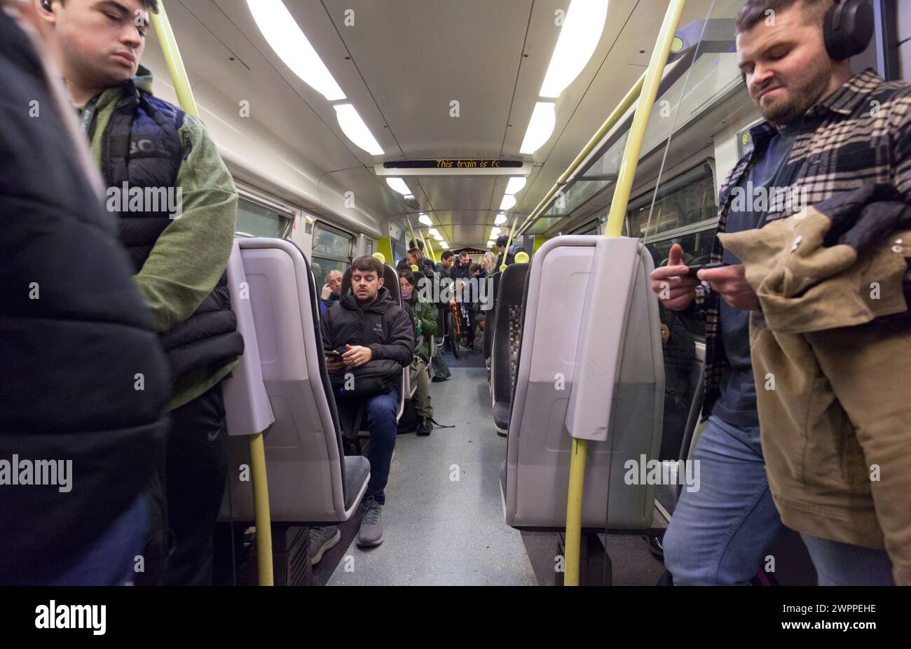 Passengers on travelling on a Merseyrail class 507 train showing ...