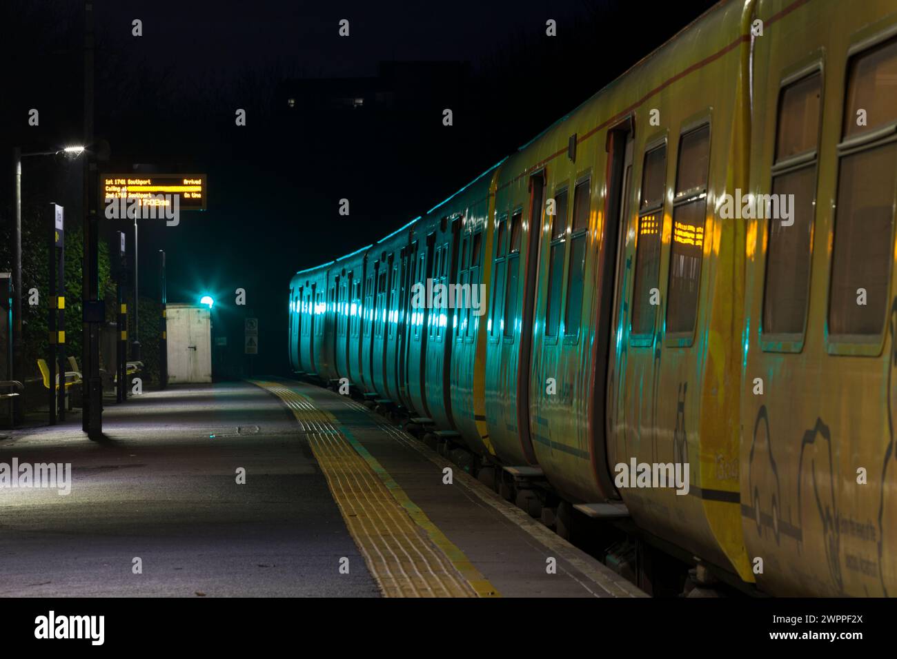 green railway signal glinting down the side of a Merseyrail train at St ...