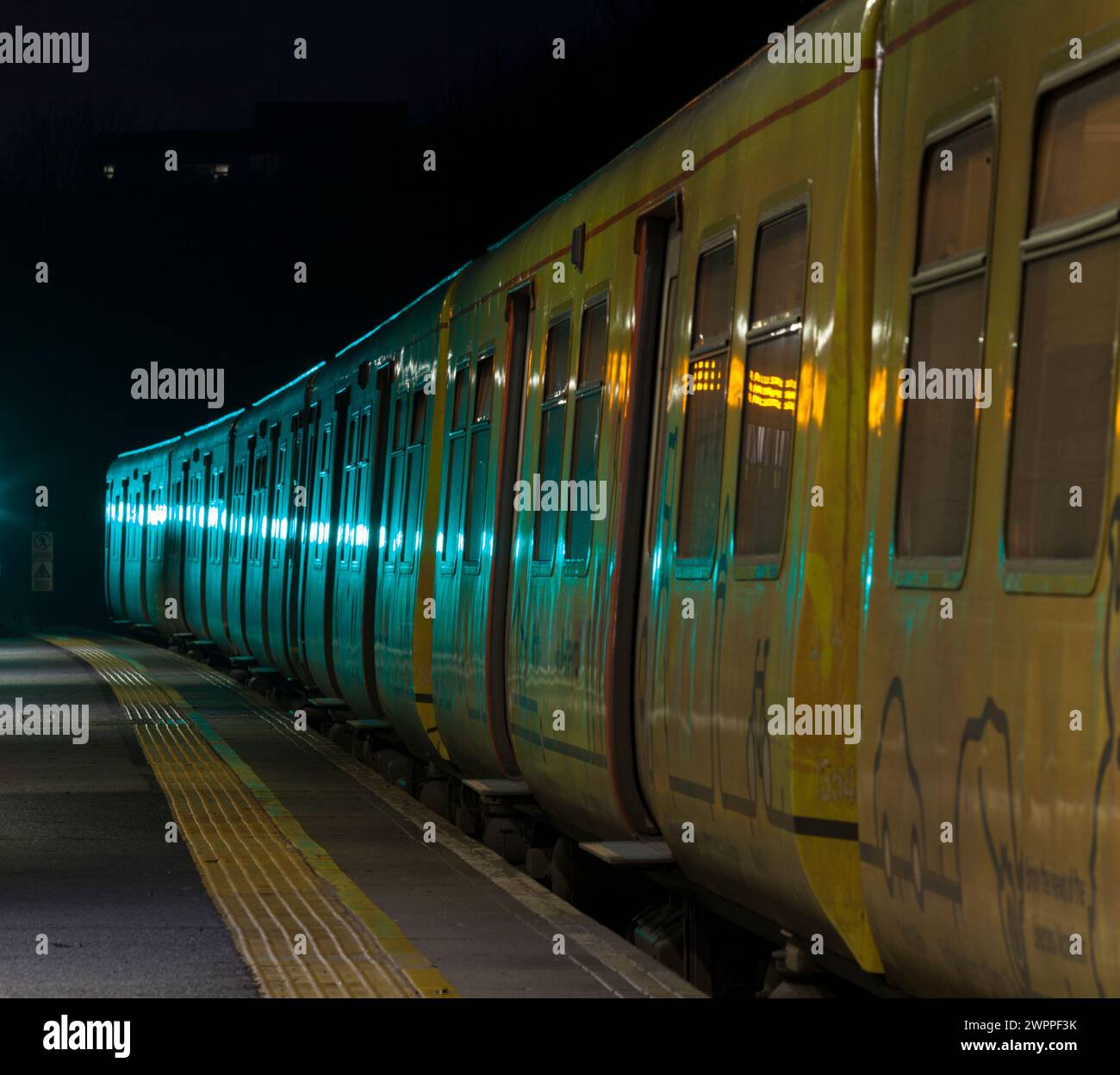 green railway signal glinting down the side of a Merseyrail train at St ...